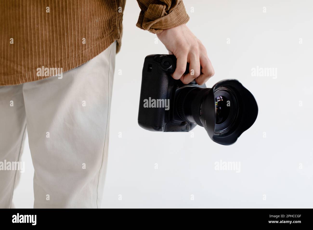Photographer standing ready to work, holding modern camera in hand ...