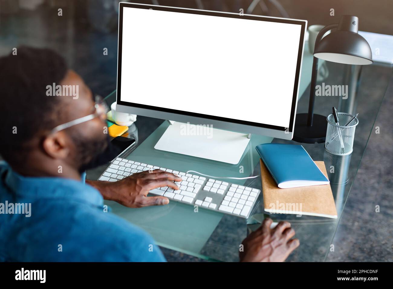 Unrecognizable black businessman using computer with empty blank screen ...