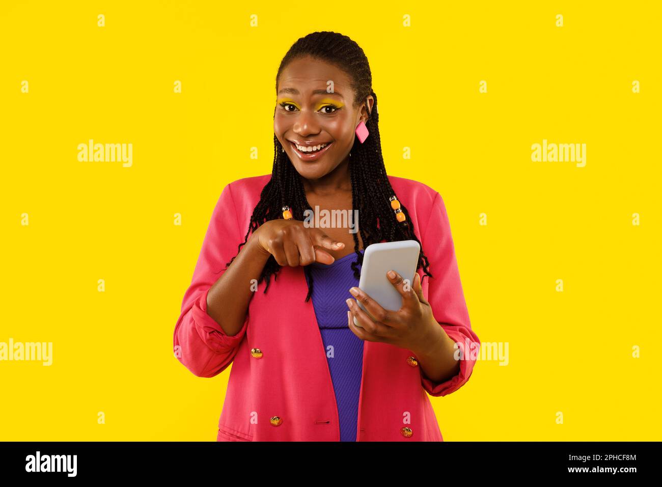 Happy Black Female Pointing At Cellphone Smiling Over Yellow Background Stock Photo - Alamy