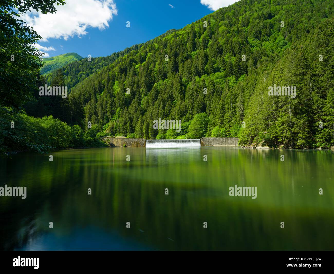 Waterfall flowing into the still lake in spring time. Uzungol waterfall ...