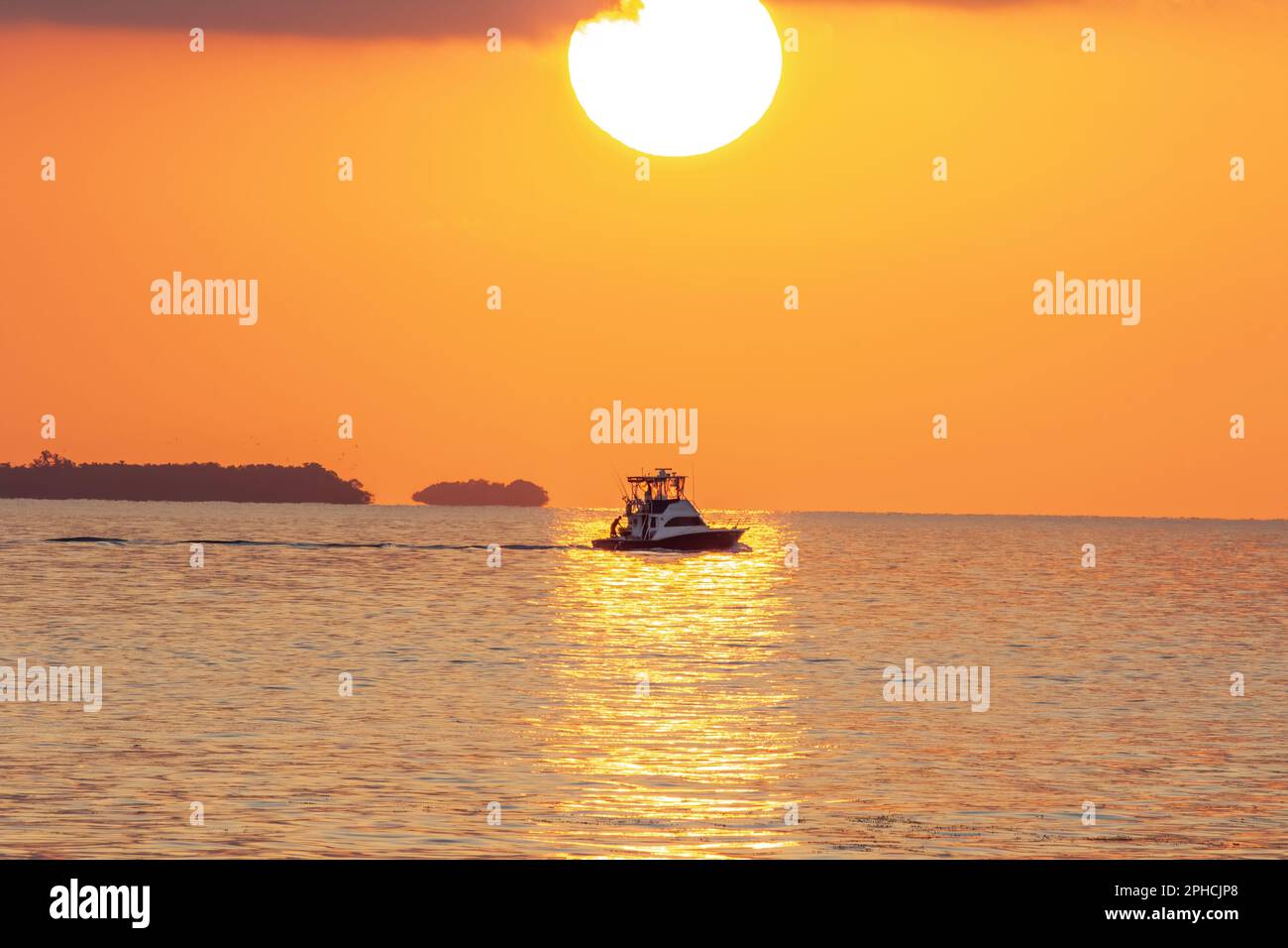 Boat during sunset in Key West Florida watch as the sun sets over the ...