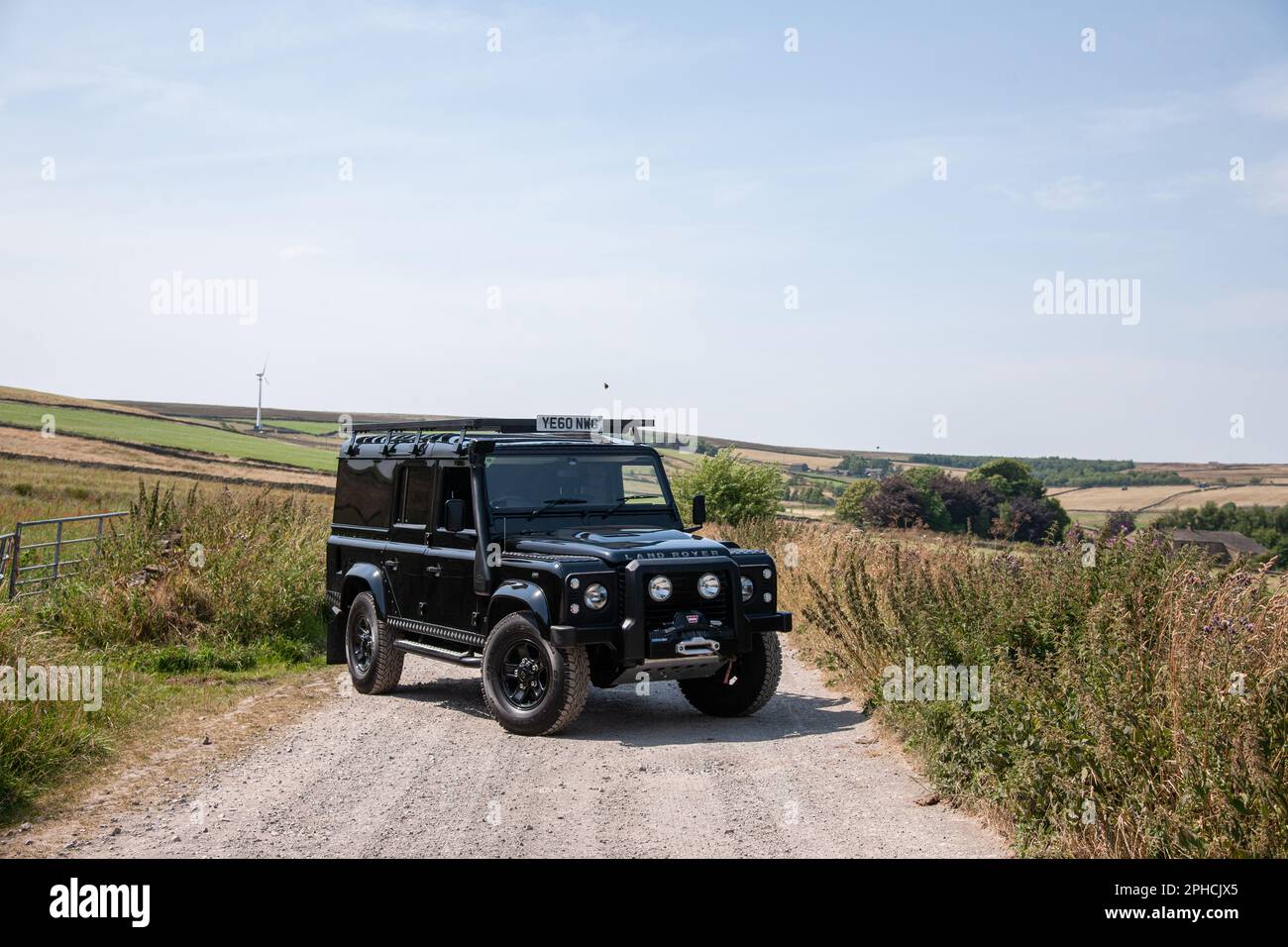 Black Land Rover Defender 110 long wheelbase parked on a gravel farm ...