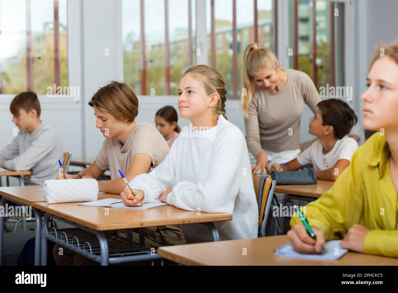 Group of school kids and teacher during lesson Stock Photo - Alamy