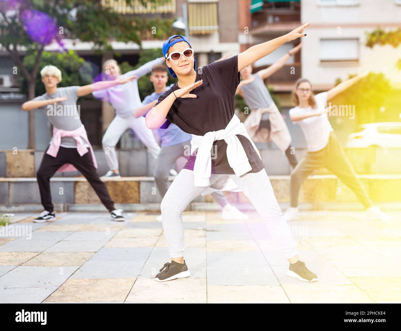 Portrait of emotional girl doing hip hop movements during group class ...