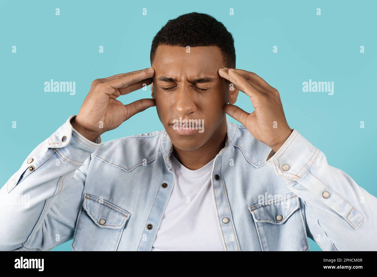 Sad millennial black guy with closed eyes suffering from headache and ...