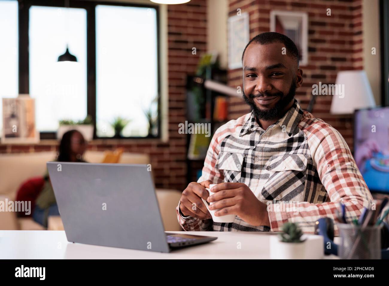 Portrait of african american programmer smiling at camera while holding ...