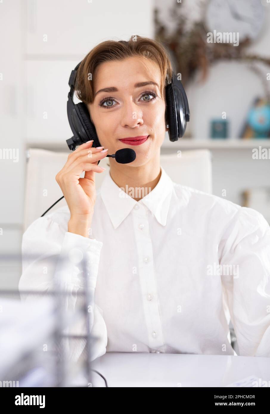 Female operator talking with customer using headset at company office ...