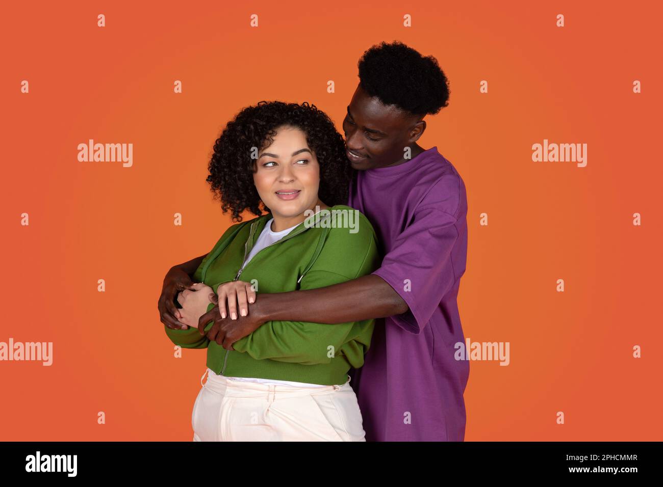 Loving african american guy hugging from behind his pretty girlfriend ...