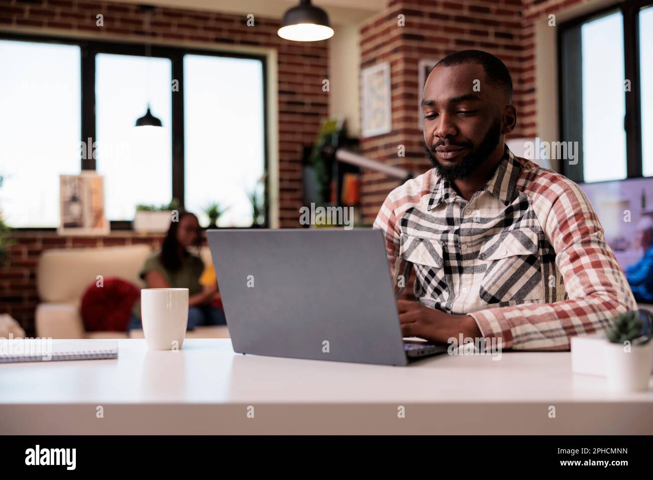 African American Programmer Writing Code Typing On Laptop Keyboard While Girlfriend Is Reading A