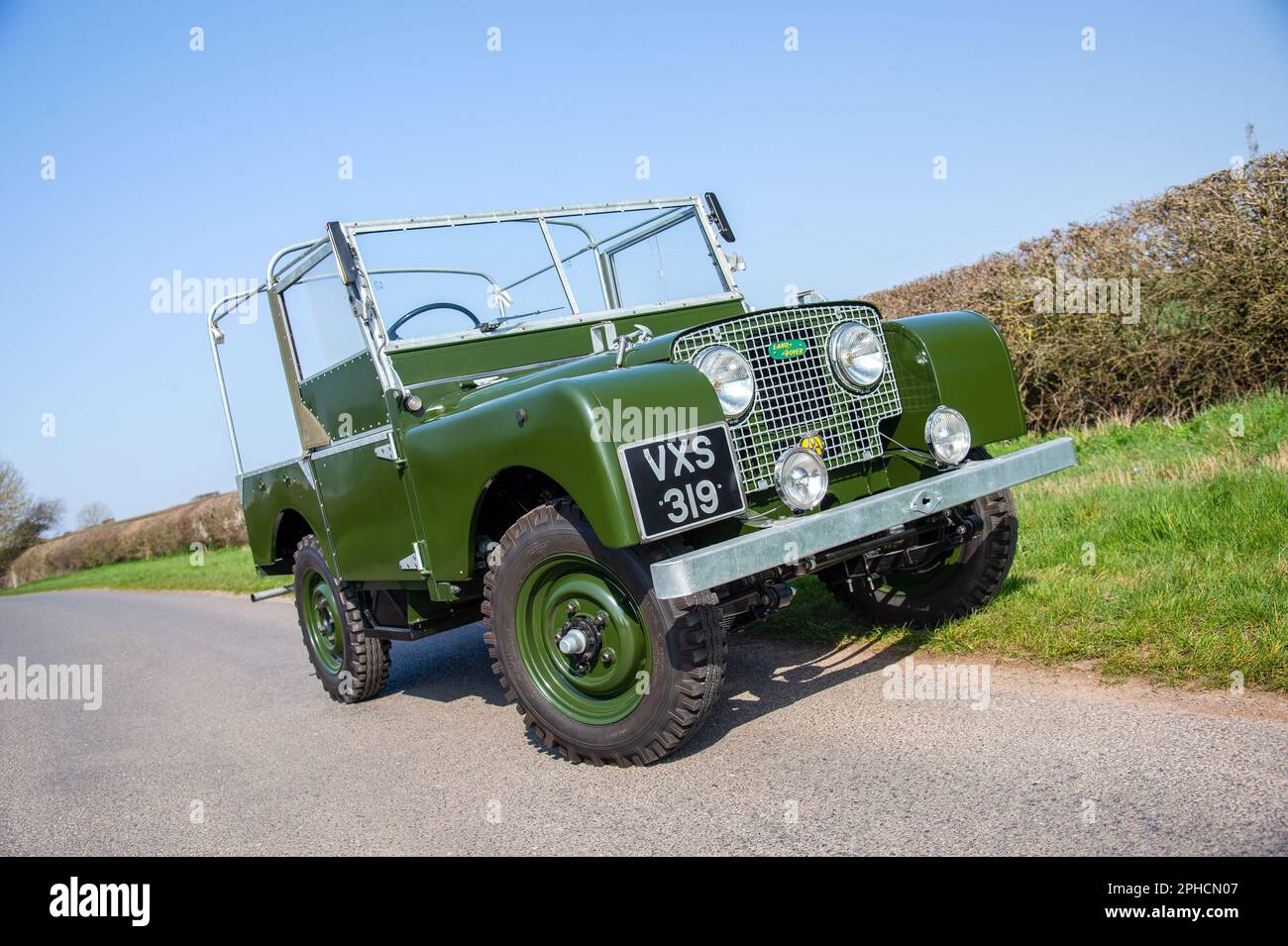 Land Rover Series One parked by the side of a country lane with a hedge ...