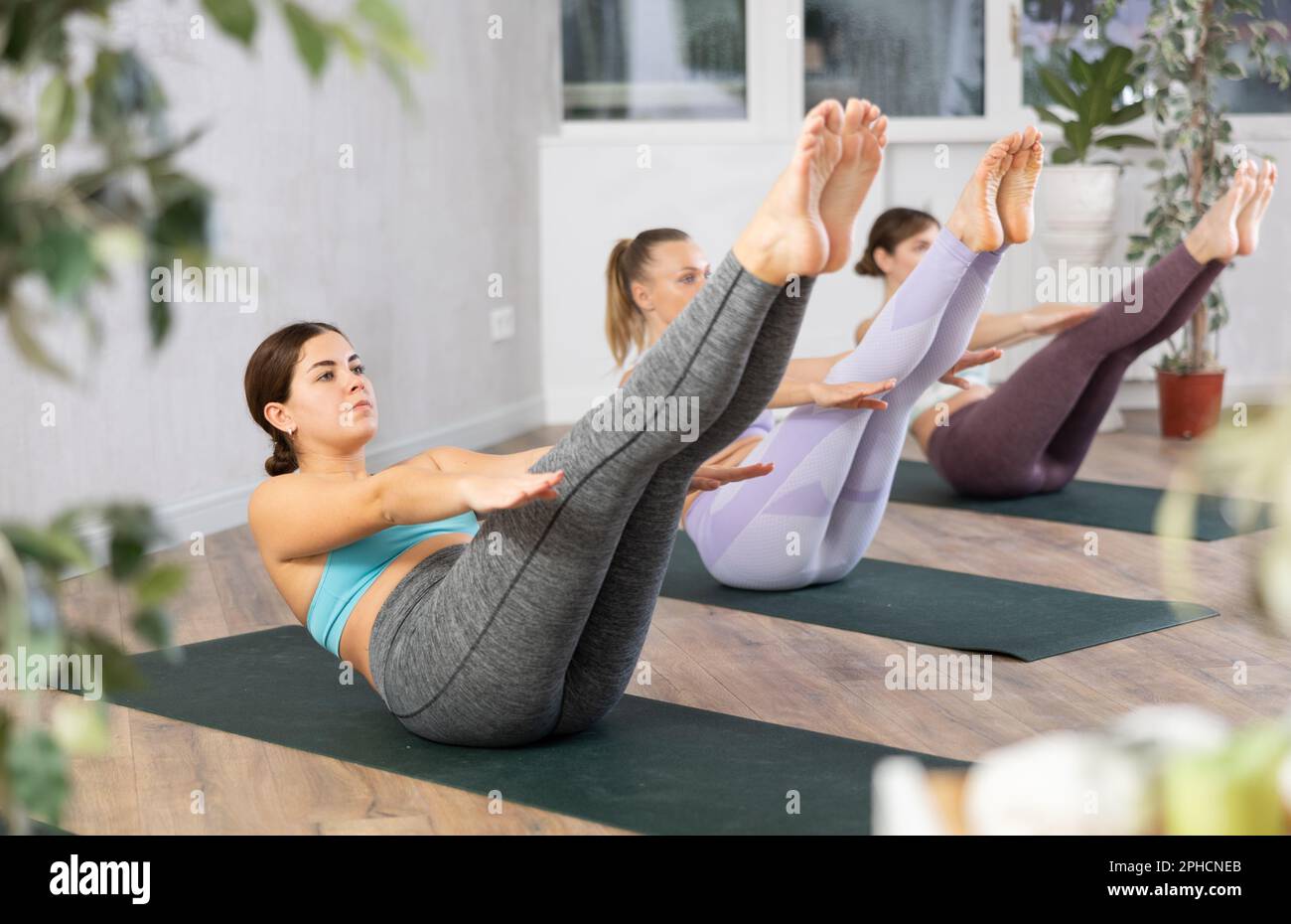 Focused active women balaning in sitting boat posture Paripurna ...