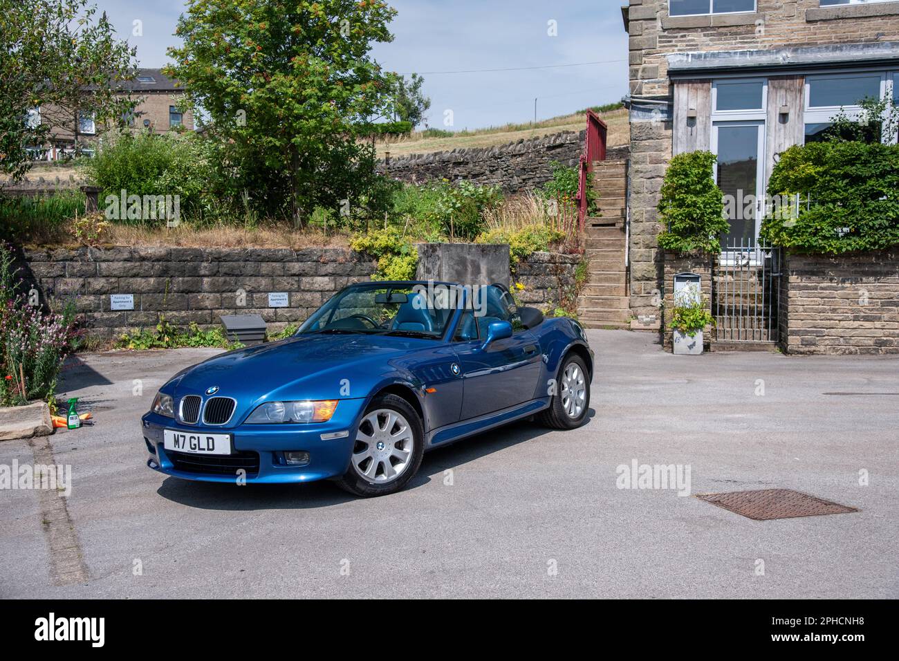BMW Z3 two-door sports car parked on a cul de sac with a stone wall and ...