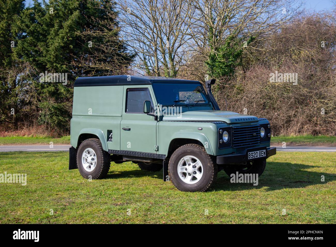 Green Land Rover Defender equipped with five-spoke alloy wheels and ...