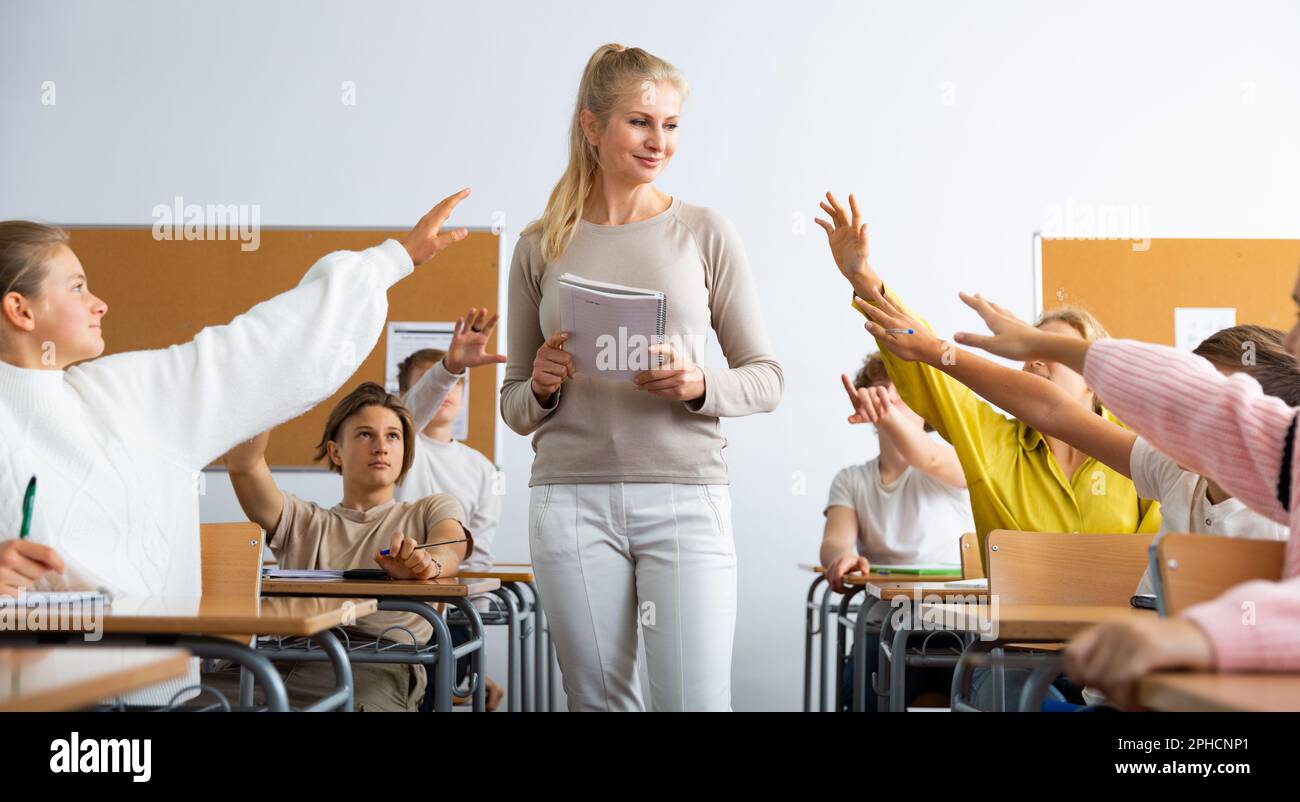 Students raise their hand to answer during lesson in class Stock Photo ...
