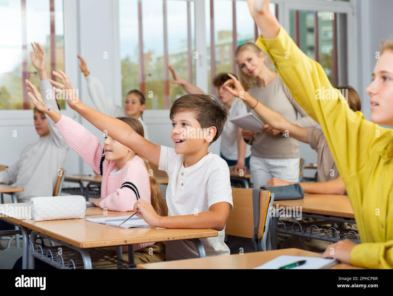 Pupils raising hands during lesson Stock Photo - Alamy