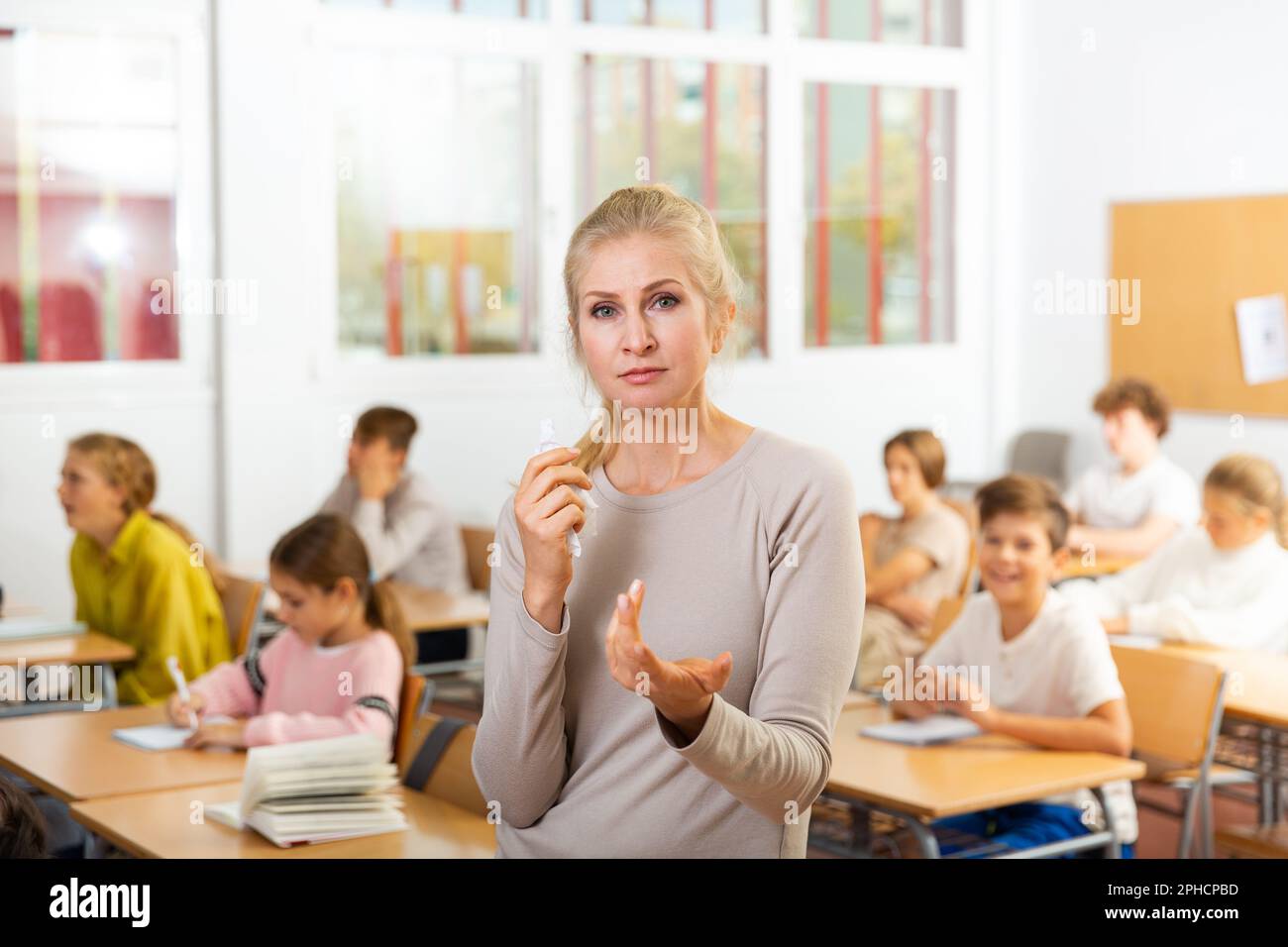 Portrait of frustrated tired teacher against the background of school ...