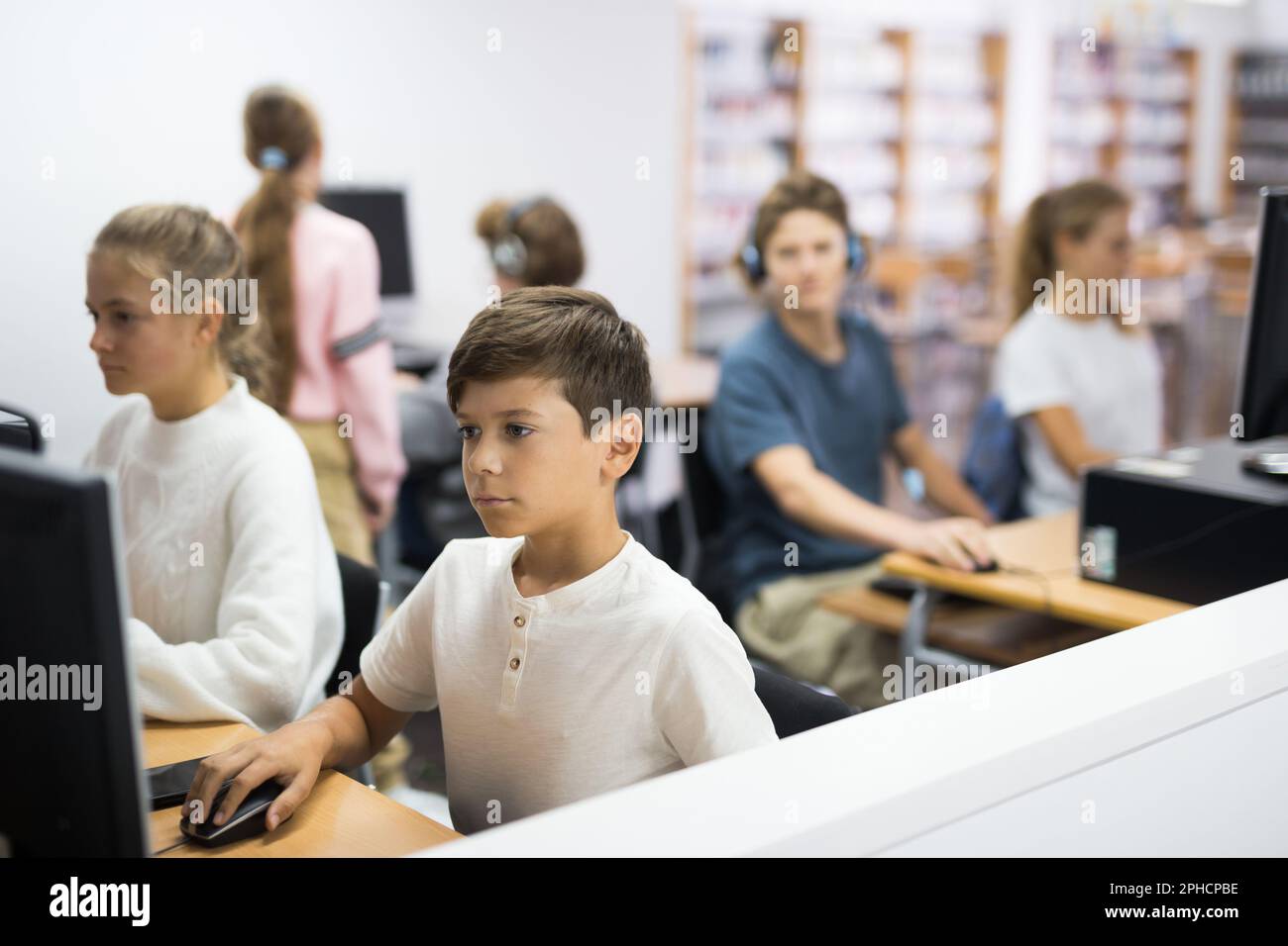 Preteen boy and girl learn to solve problems on computer in school ...