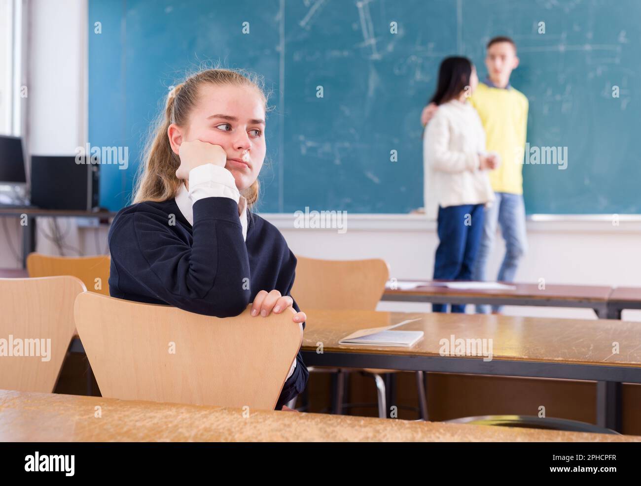 Tired student girl sitting in classroom Stock Photo - Alamy