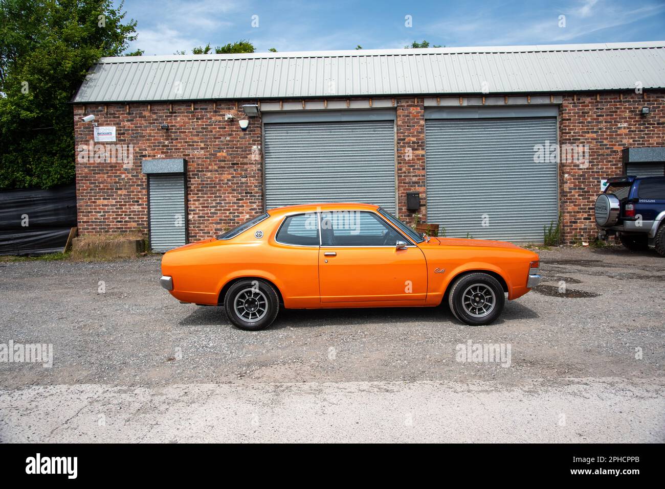 A bright metallic orange 1977 Mitsubishi Colt Galant 1.7 GSstanding in ...