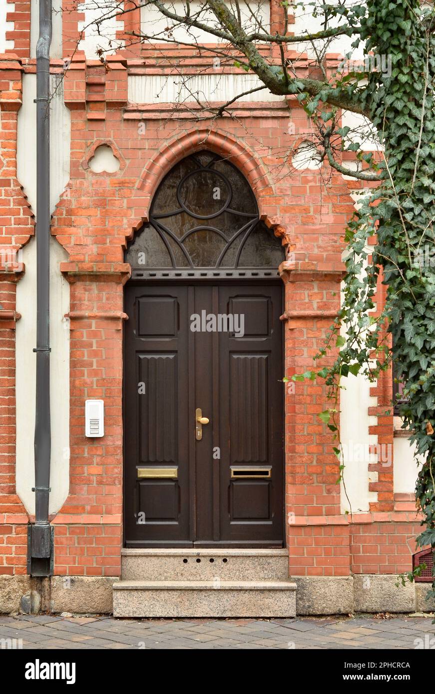 View of brick building with wooden door Stock Photo - Alamy