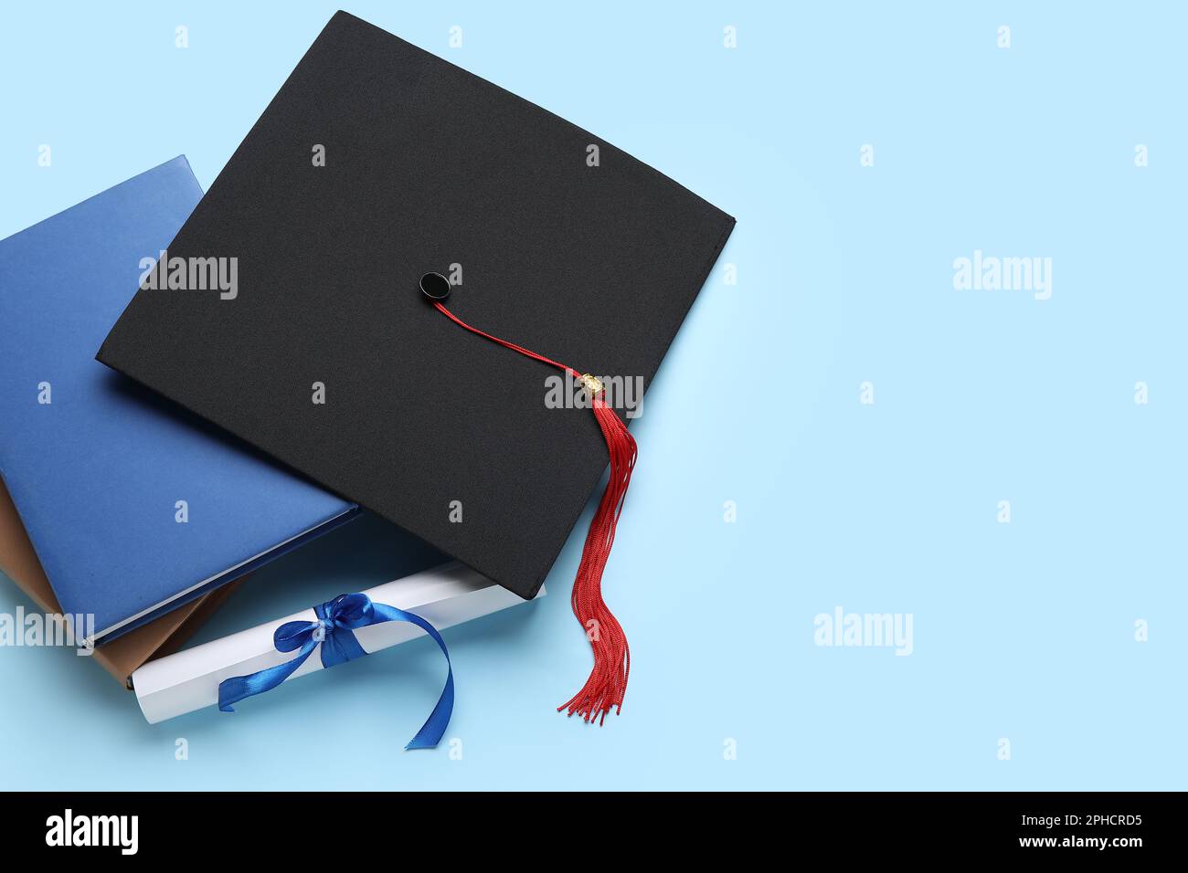Diploma with ribbon, graduation hat and books on blue background Stock ...