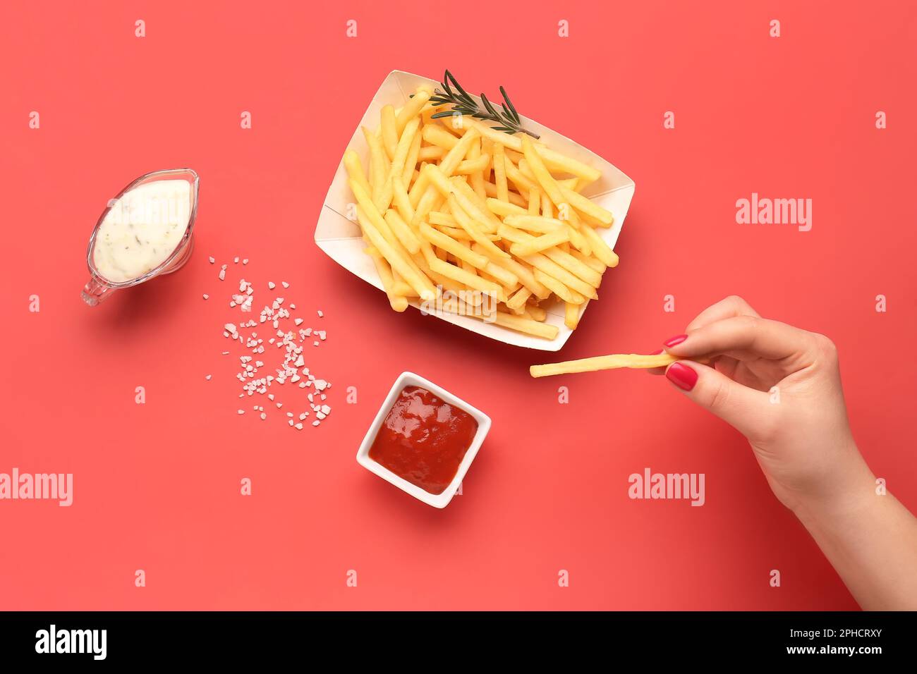 Woman holding french fries on red background Stock Photo - Alamy