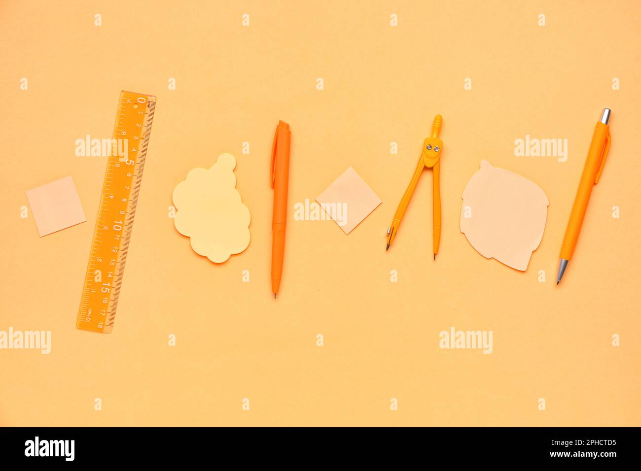 Composition with sticky notes, pens and ruler on yellow background ...