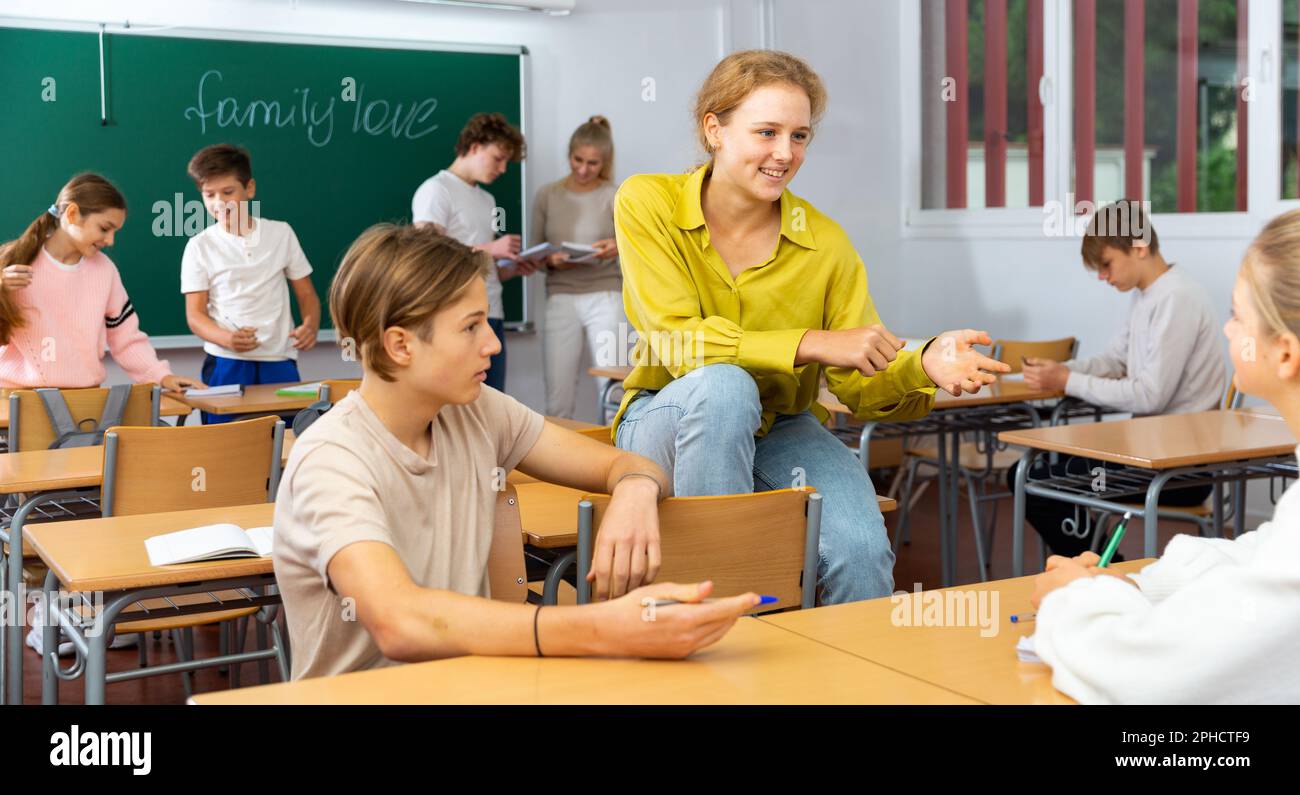 Teenage school pupils talking during break in classroom Stock Photo - Alamy