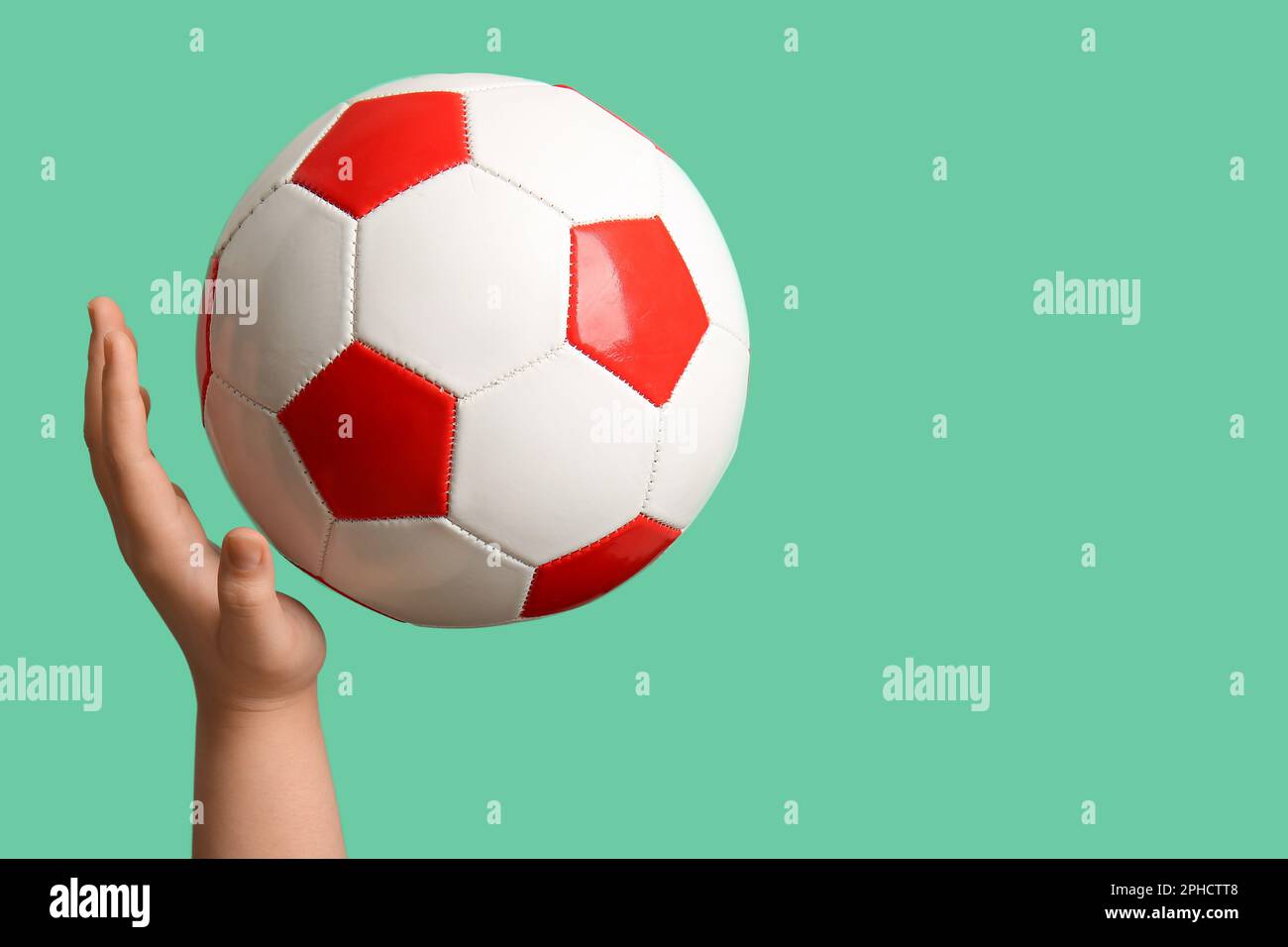 Child's hand with soccer ball on turquoise background Stock Photo - Alamy