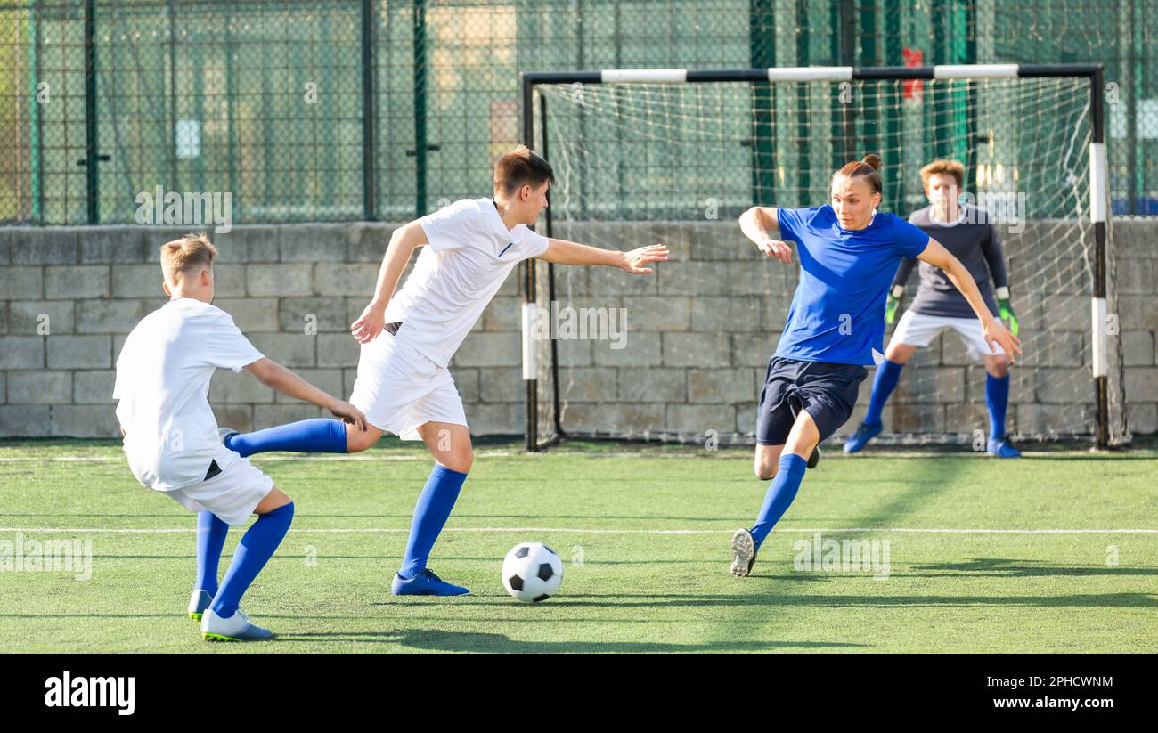 Game of football match between two teams of teenagers in white and blue ...