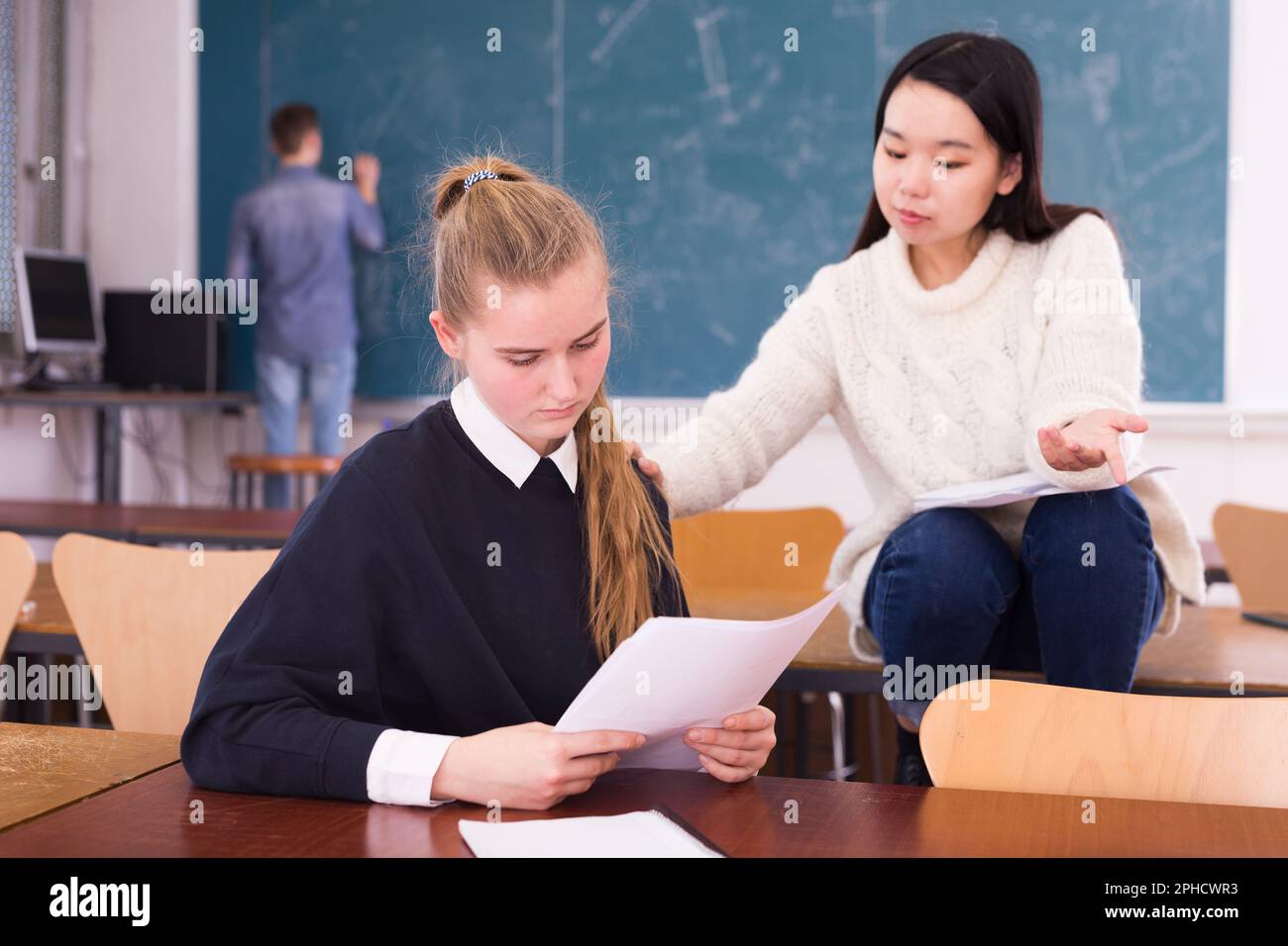 Chinese girl student comforting female friend Stock Photo - Alamy
