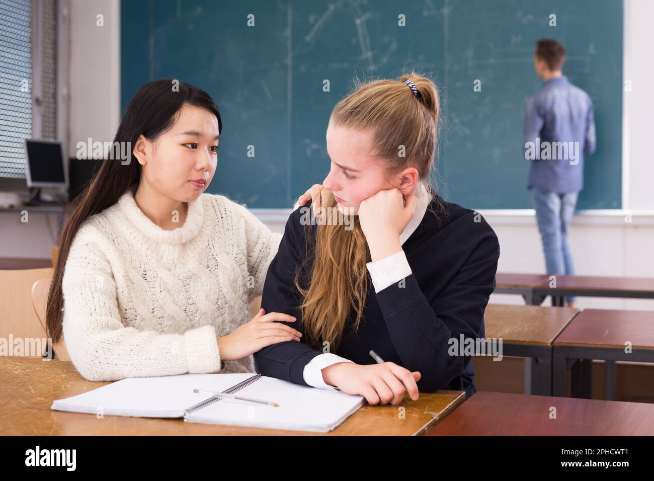 Tired female students during writing notes in classroom Stock Photo - Alamy