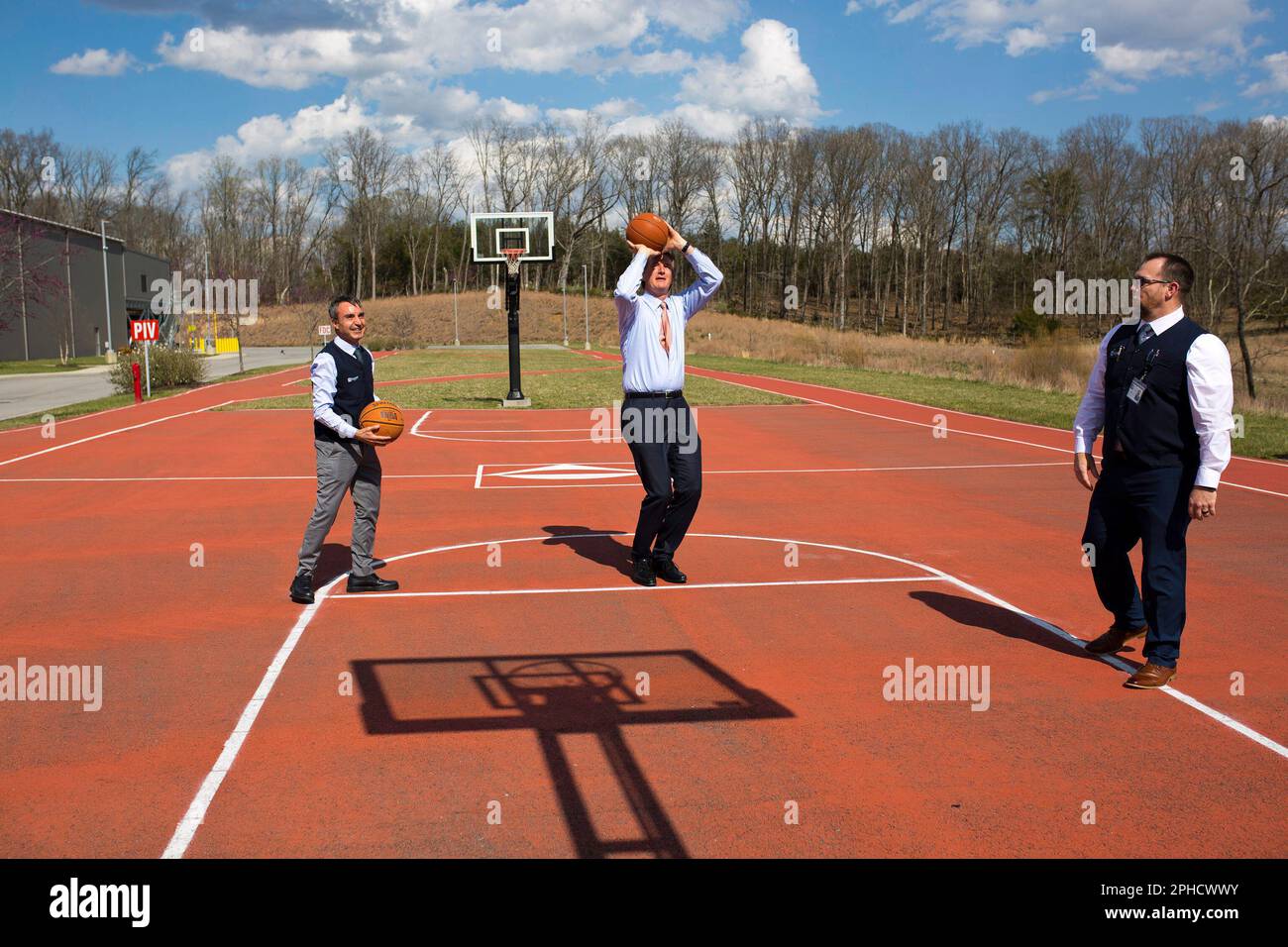 Virginia Gov. Glenn Youngkin, center, shoots a basketball with Chief ...
