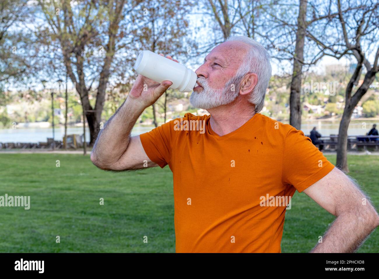 A healthy senior man is catching his breath after exercising in the ...