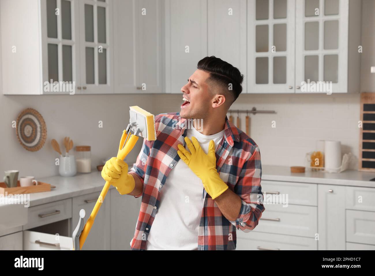 Man with mop singing while cleaning at home Stock Photo - Alamy
