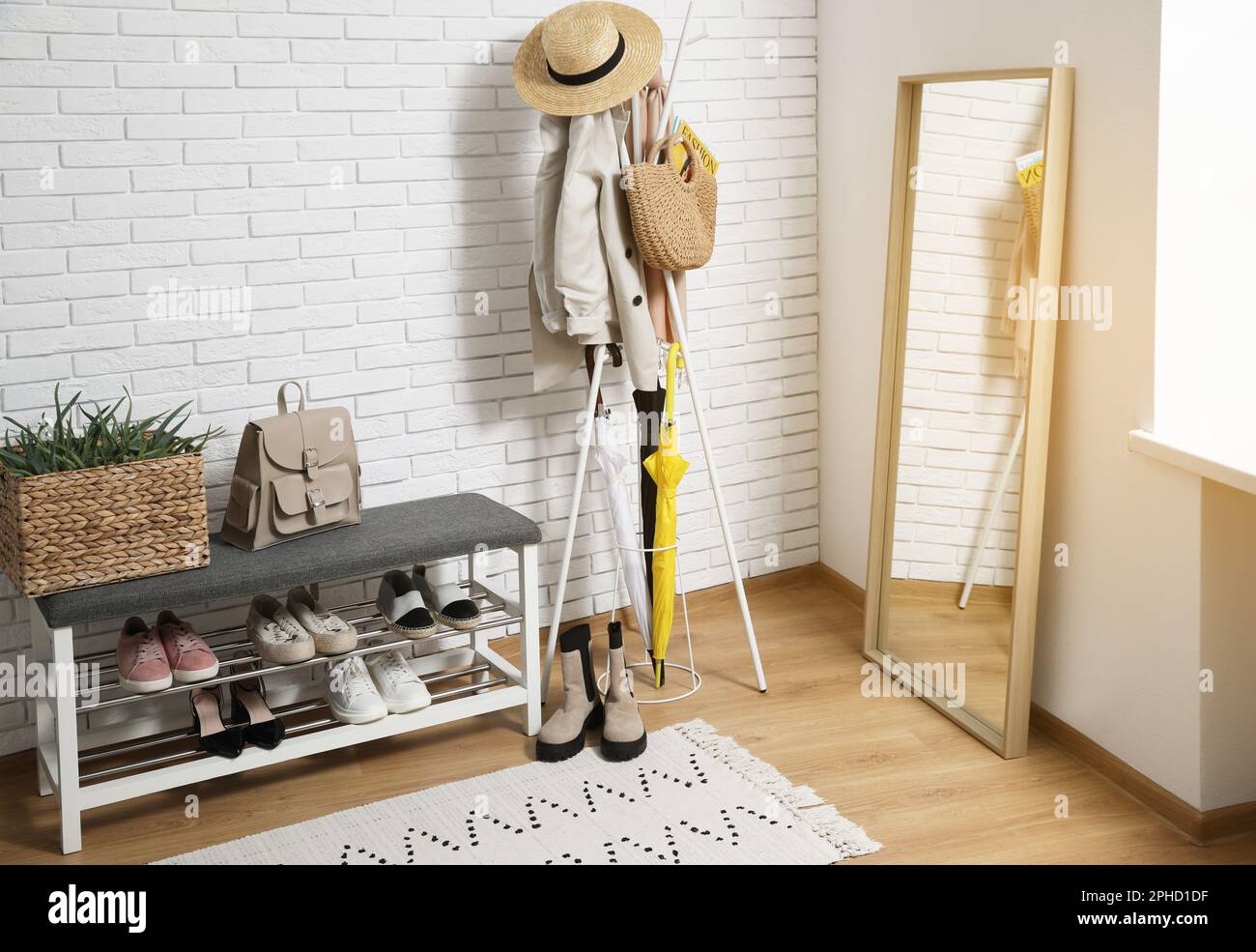 Stylish hallway interior with coat rack, shoe storage bench and mirror ...