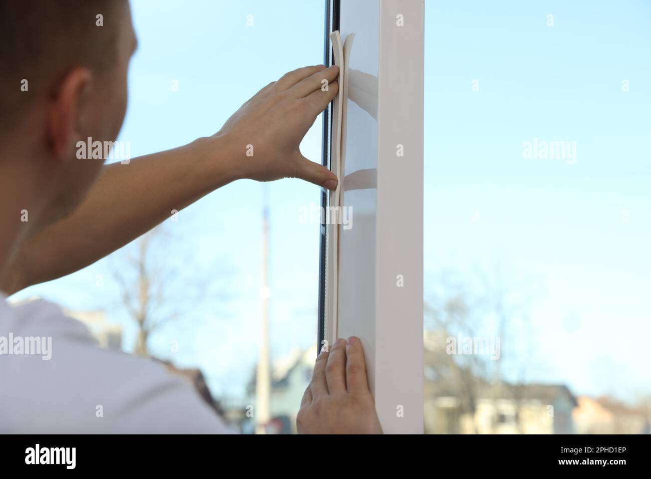 Construction worker putting sealing foam tape on window indoors ...