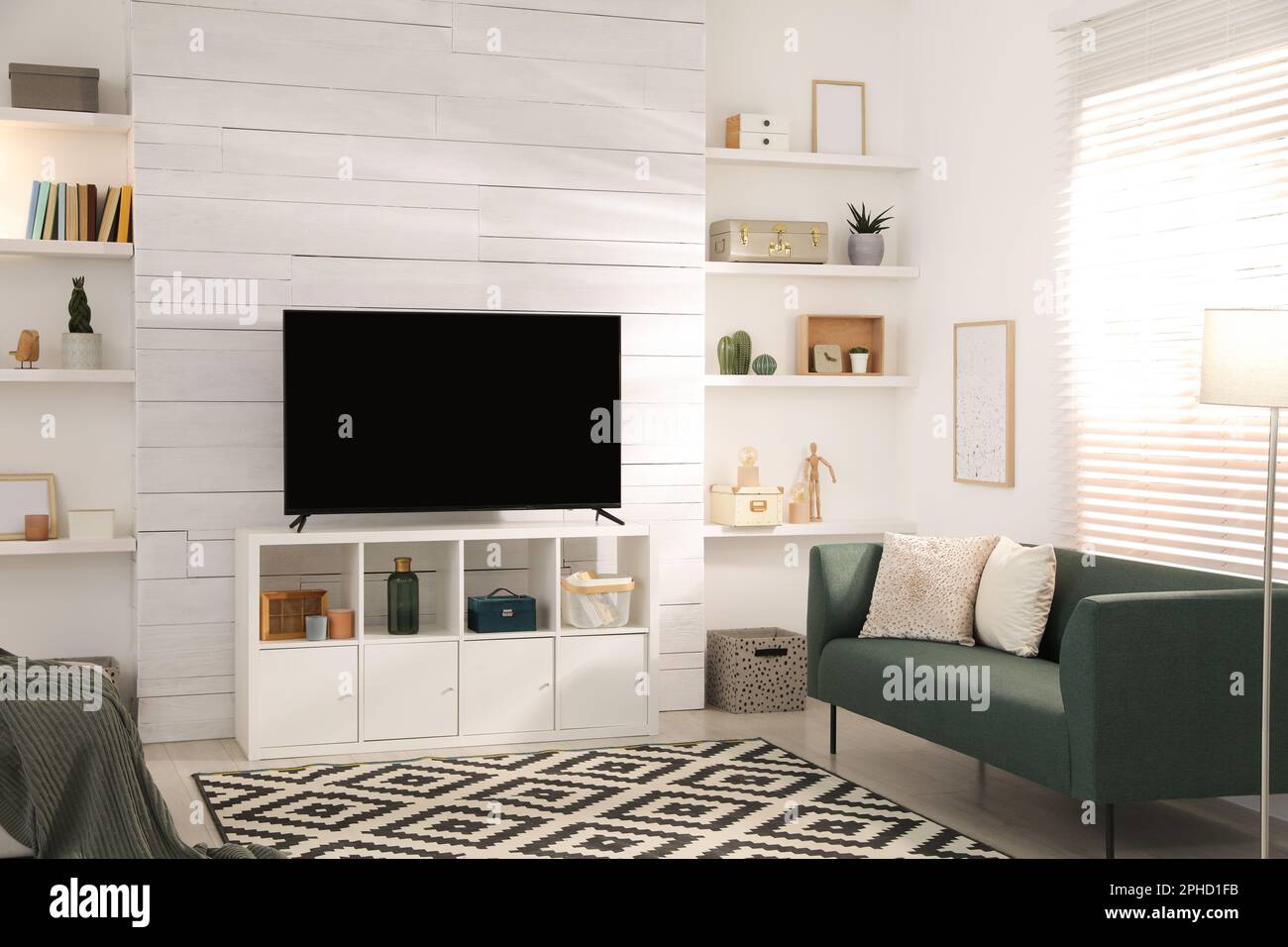 Cozy room interior with stylish furniture, decor and modern TV set ...