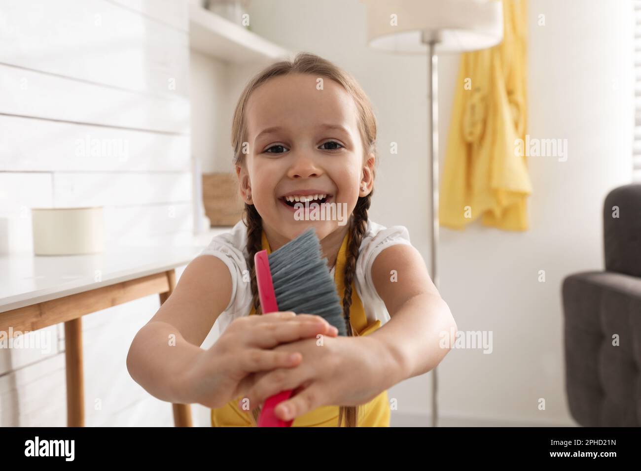 Cute little girl with brush singing at home Stock Photo - Alamy