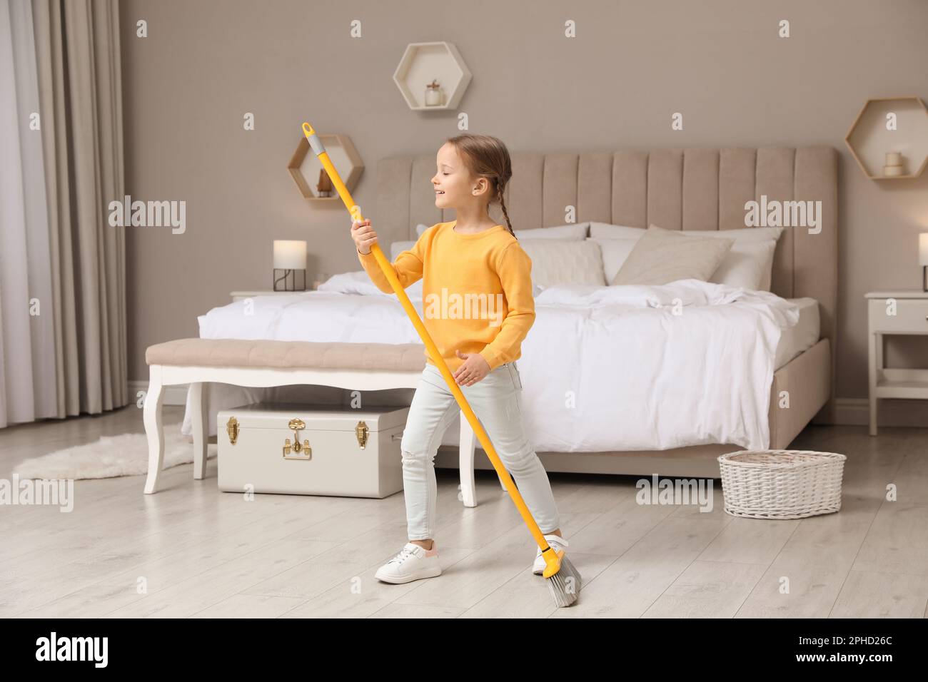 Cute little girl with broom singing while cleaning in bedroom Stock ...