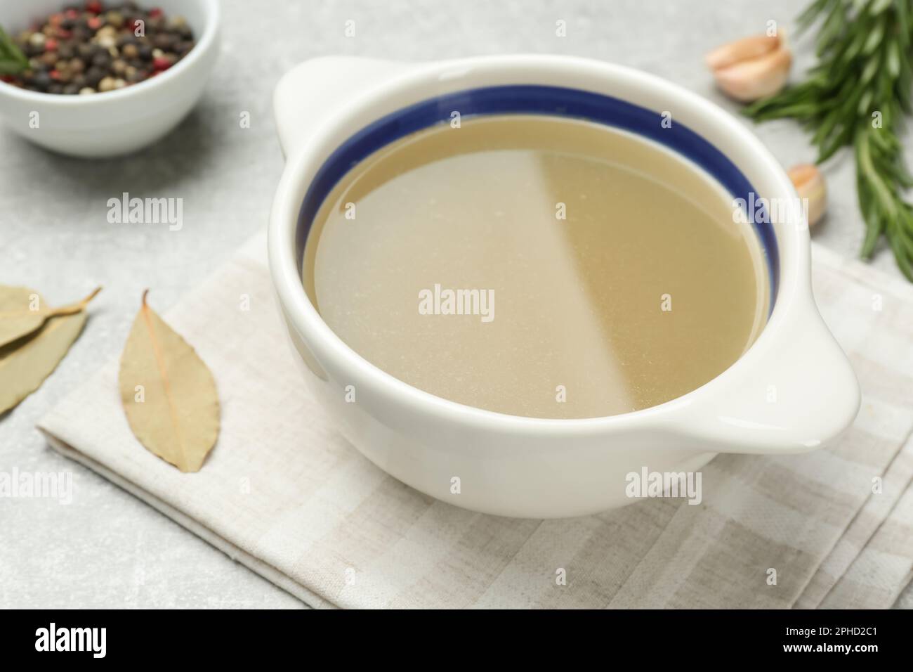 Bowl with delicious bone broth on light grey table Stock Photo - Alamy