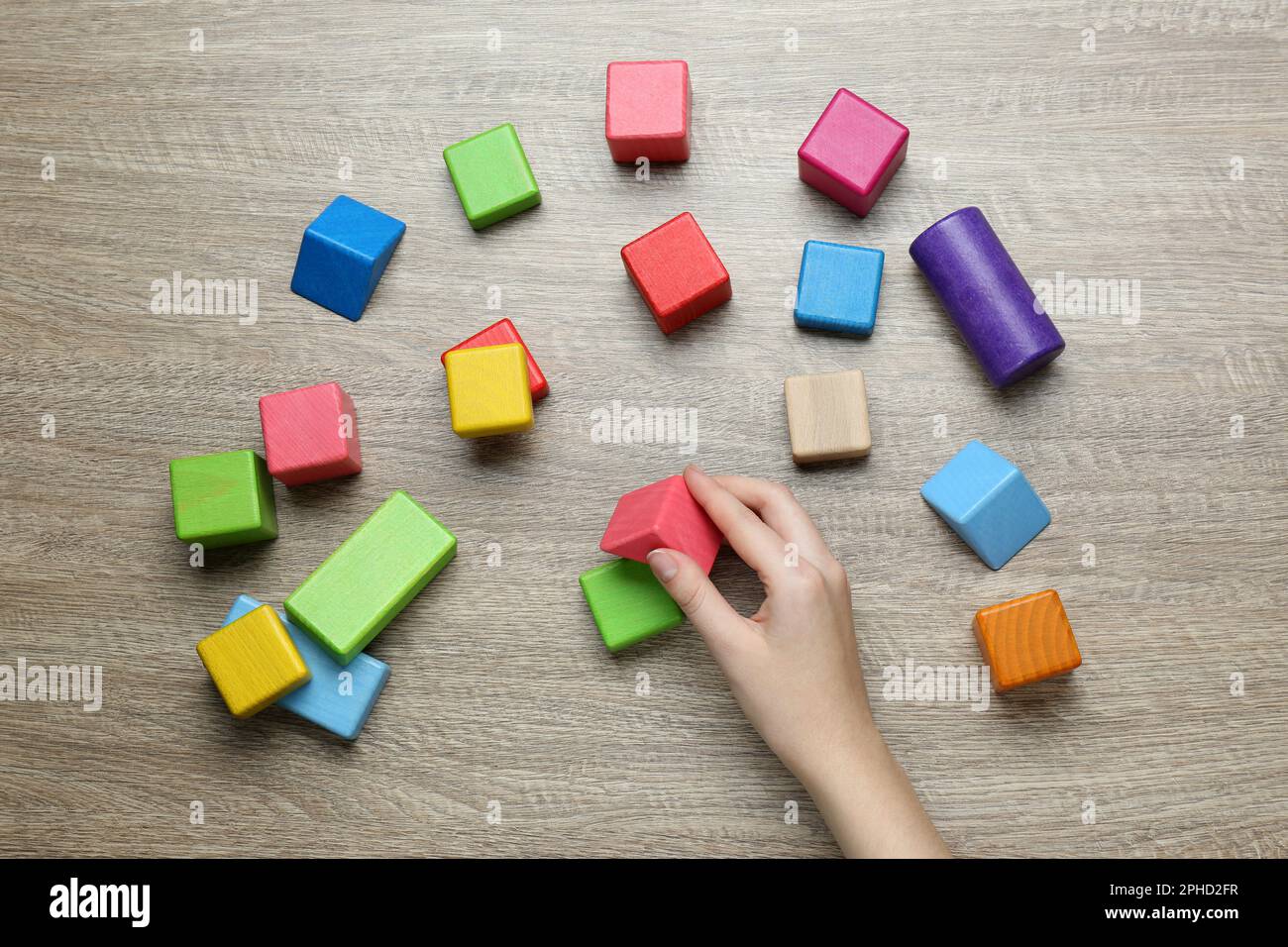 ABA therapist with colorful building blocks at wooden table, top view ...