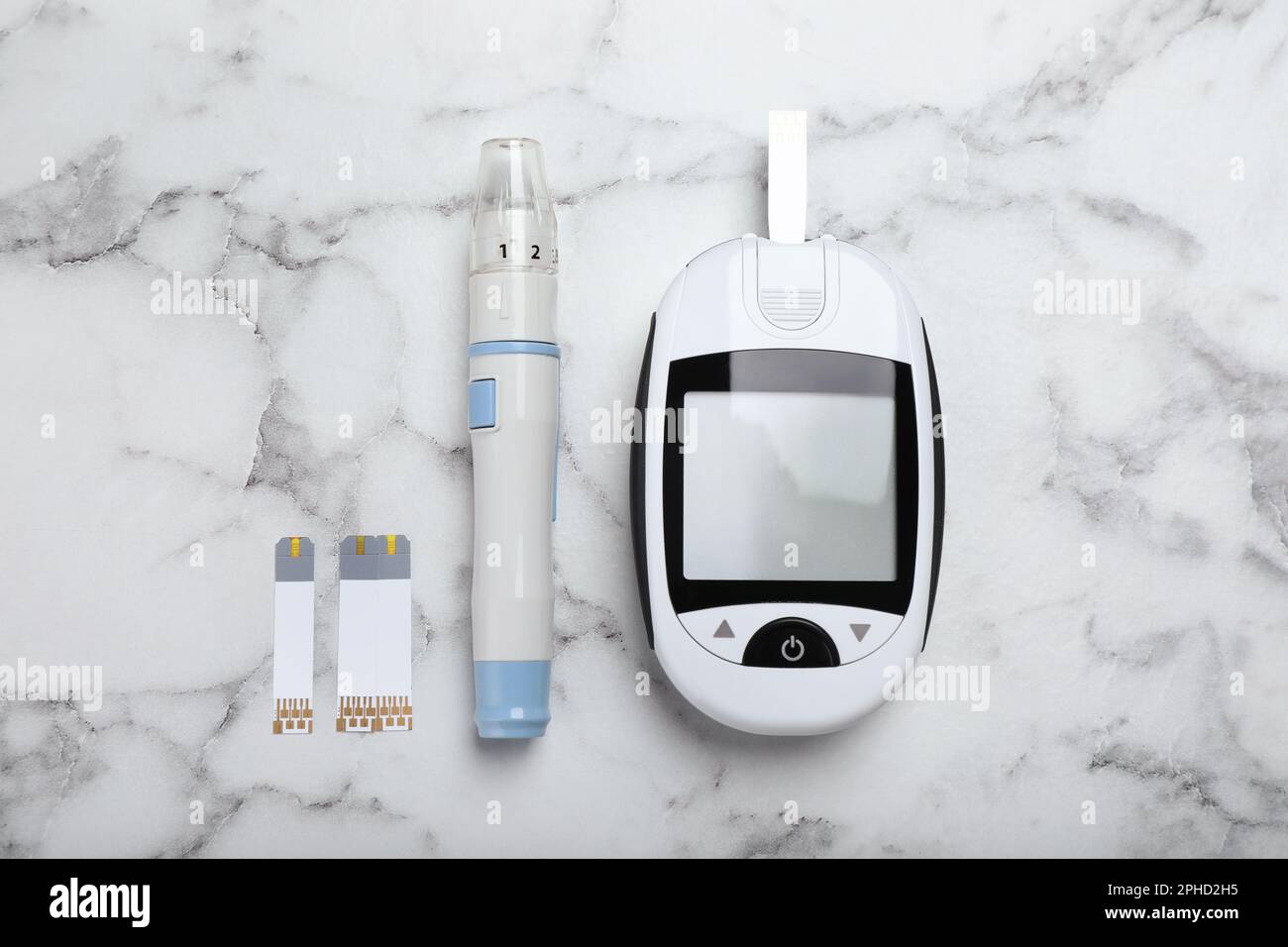 Glucometer, lancet pen and strips on white marble table, flat lay ...