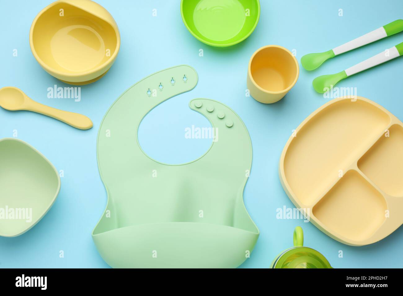 Flat lay composition with baby feeding accessories and bib on light ...