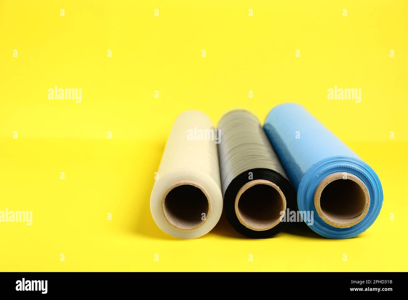 Rolls of different stretch wrap on yellow background. Space for text ...