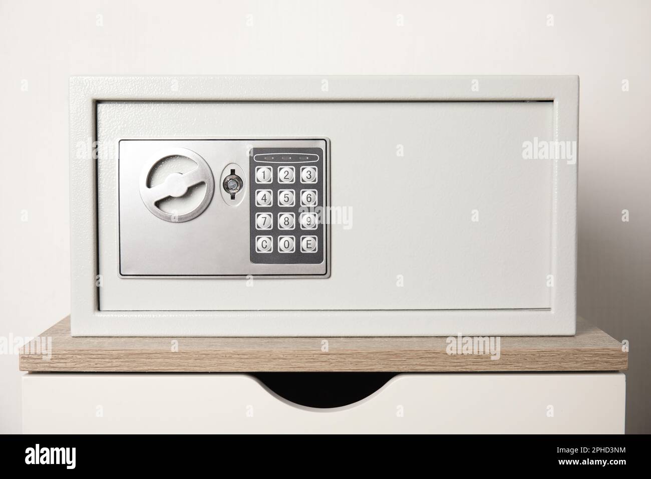 Closed steel safe on wooden table against white background Stock Photo ...