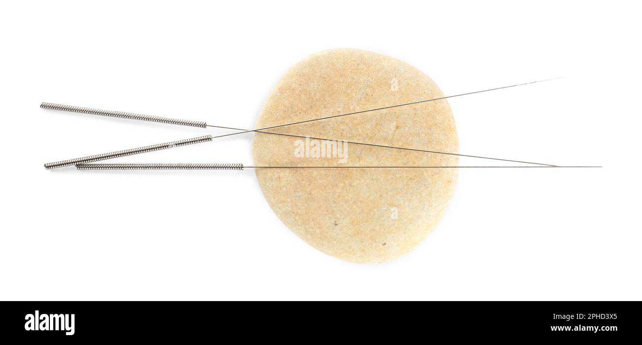 Many needles for acupuncture and stone on white background, top view ...