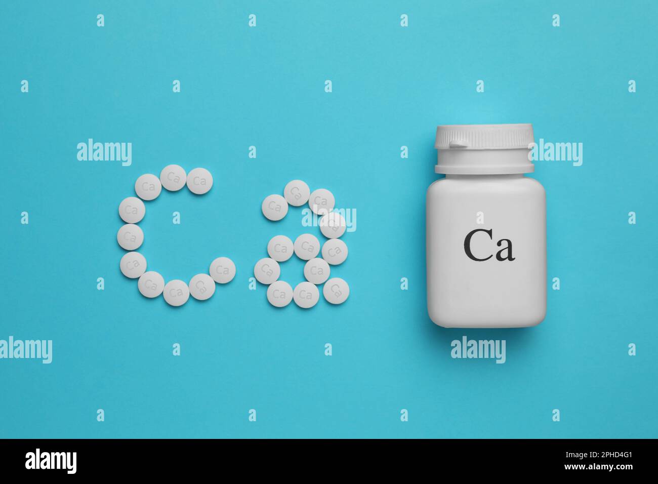 Flat lay composition with calcium supplement pills on light blue ...