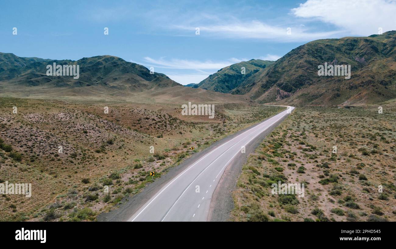 Asphalt road leading into the gorge of the mountains. Deserted terrain ...