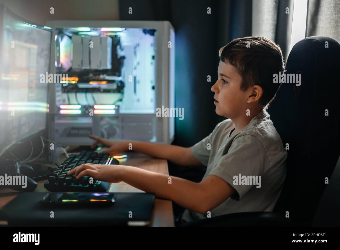 Professional teenager gamer playing video games. The boy is typing text ...